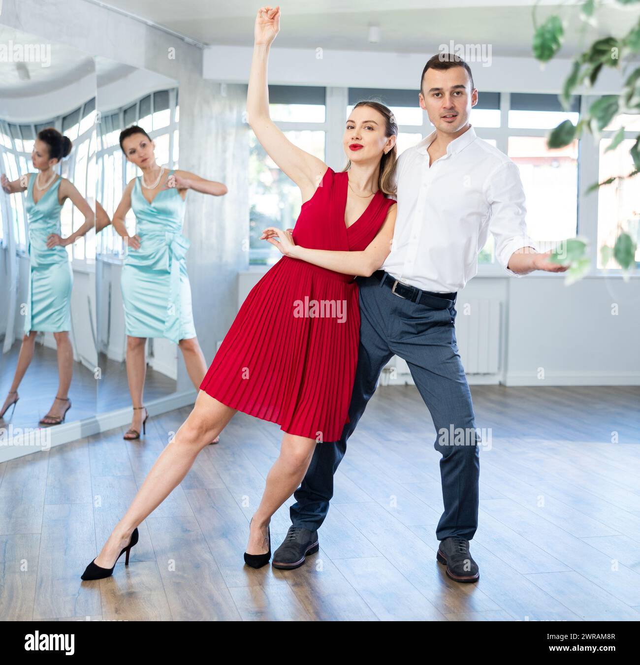 Couple in stage costumes learns tango dancing during individual lesson ...