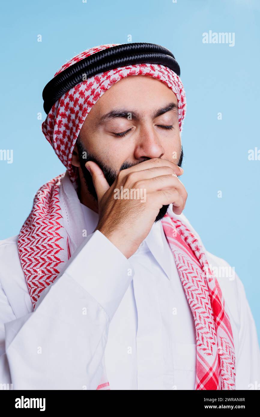 Sleepy man with closed eyes wearing traditional muslim headdress and ...