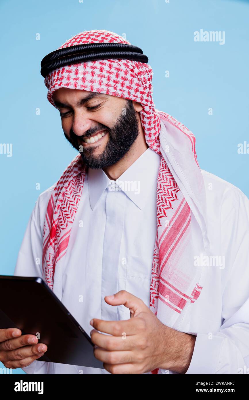 Arab man laughing while enjoying internet entertainment activity on ...