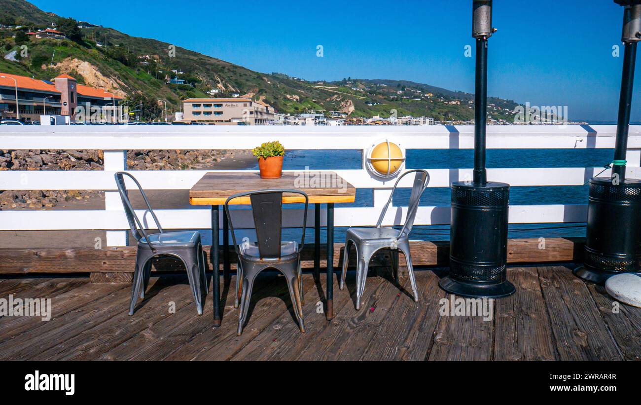 Table and chairs on the pier by the ocean. Empty table for two ...