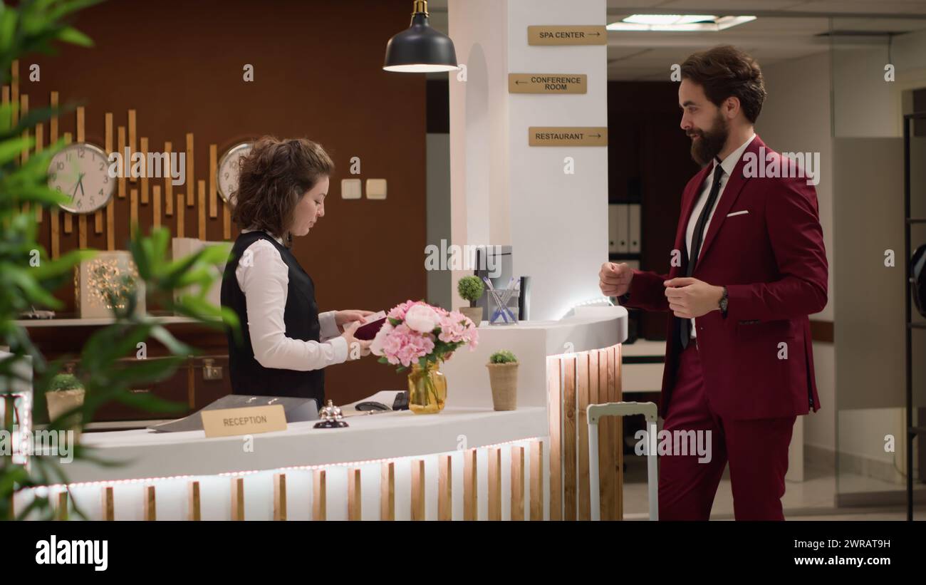 Guest offers passport for registration and check in procedure, hotel concierge verifying id to ...