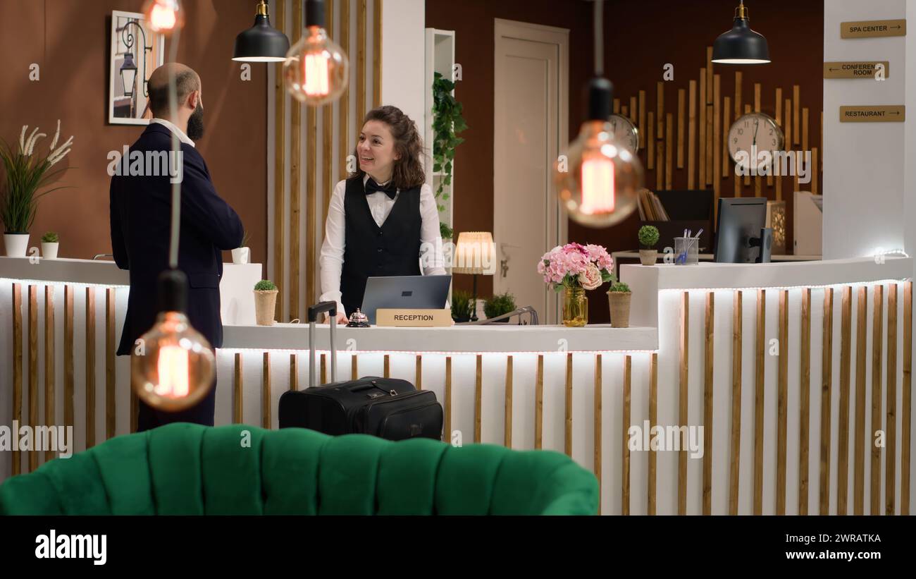 Hotel receptionist attending to client hi-res stock photography and ...