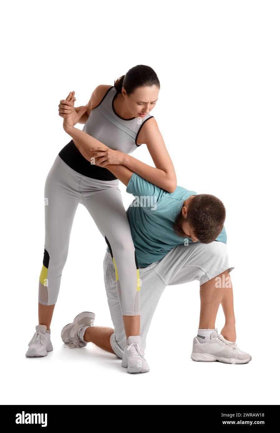 Young woman fighting with instructor of self-defence course on white ...