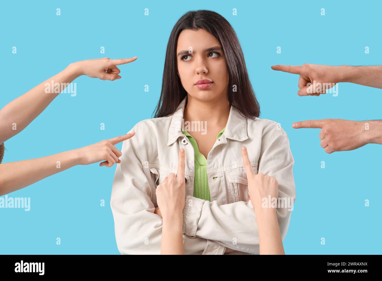 People pointing at sad young woman on blue background. Accusation ...