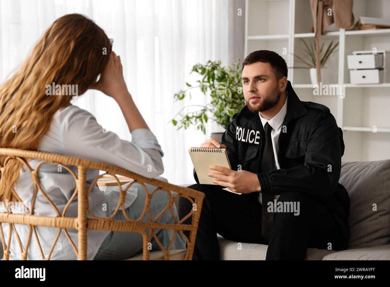 Male police officer with victim at home Stock Photo - Alamy