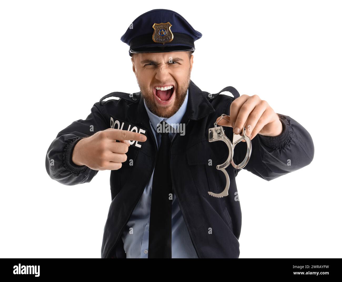 Angry male police officer pointing at handcuffs on white background ...