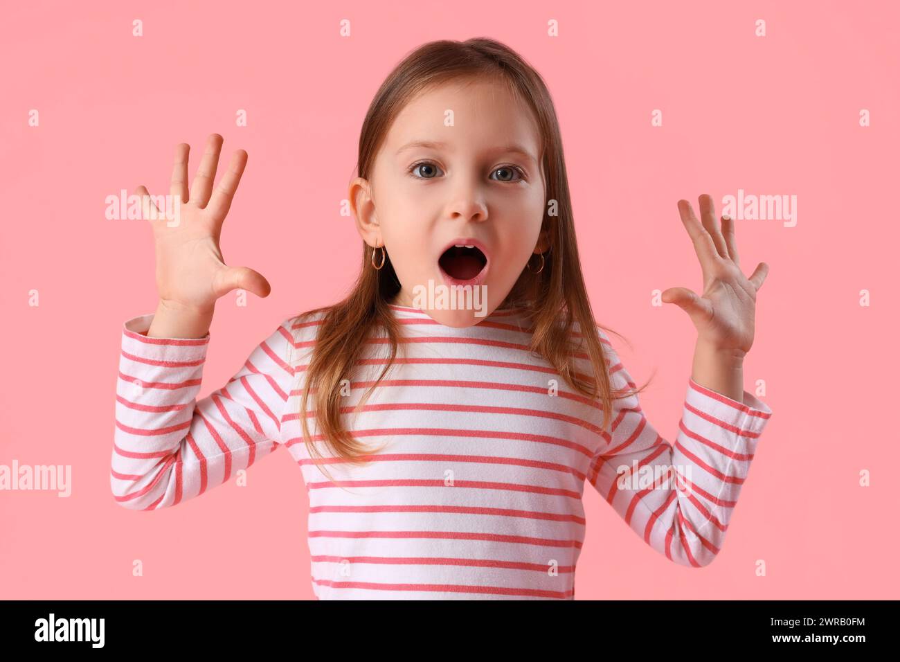 Shocked little girl on pink background Stock Photo - Alamy