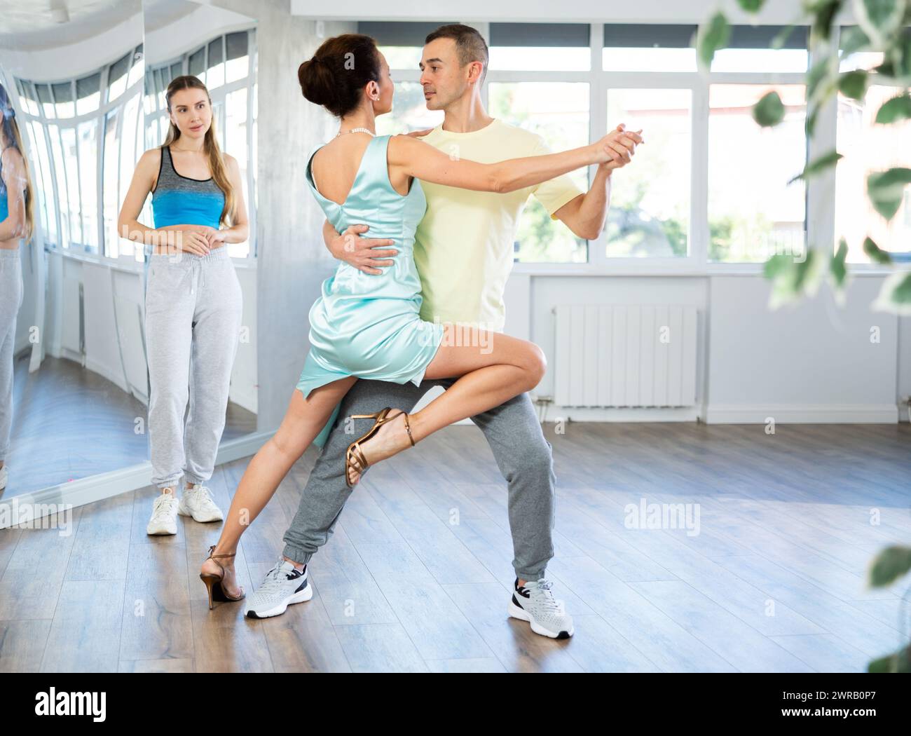 Female tango teacher performing with male student in dance hall Stock ...