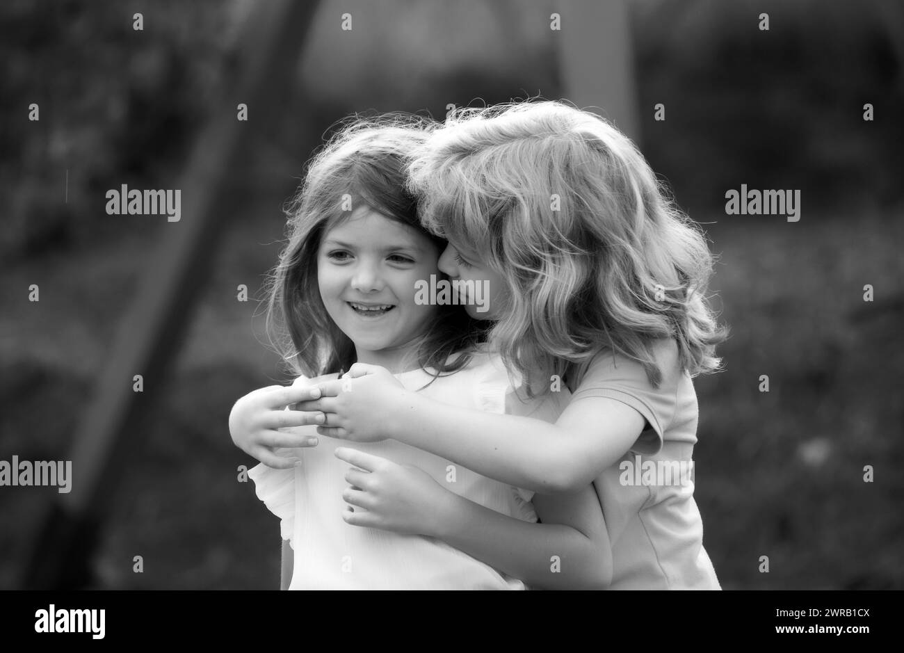 Portrait of cute boy and shy girl on summer field. Children in summer ...
