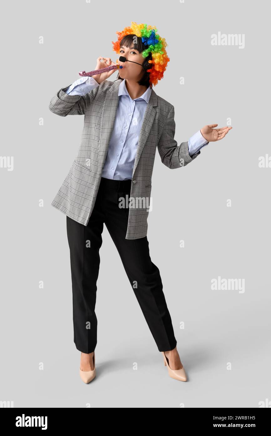 Funny young female technical support worker with headset and party ...