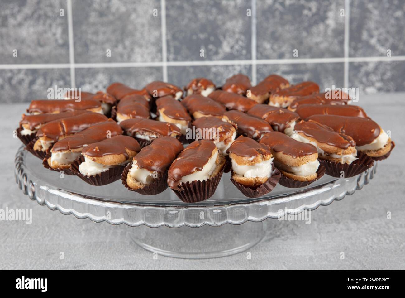 Eclairs with chocolate topping on serving plate. Traditional french ...