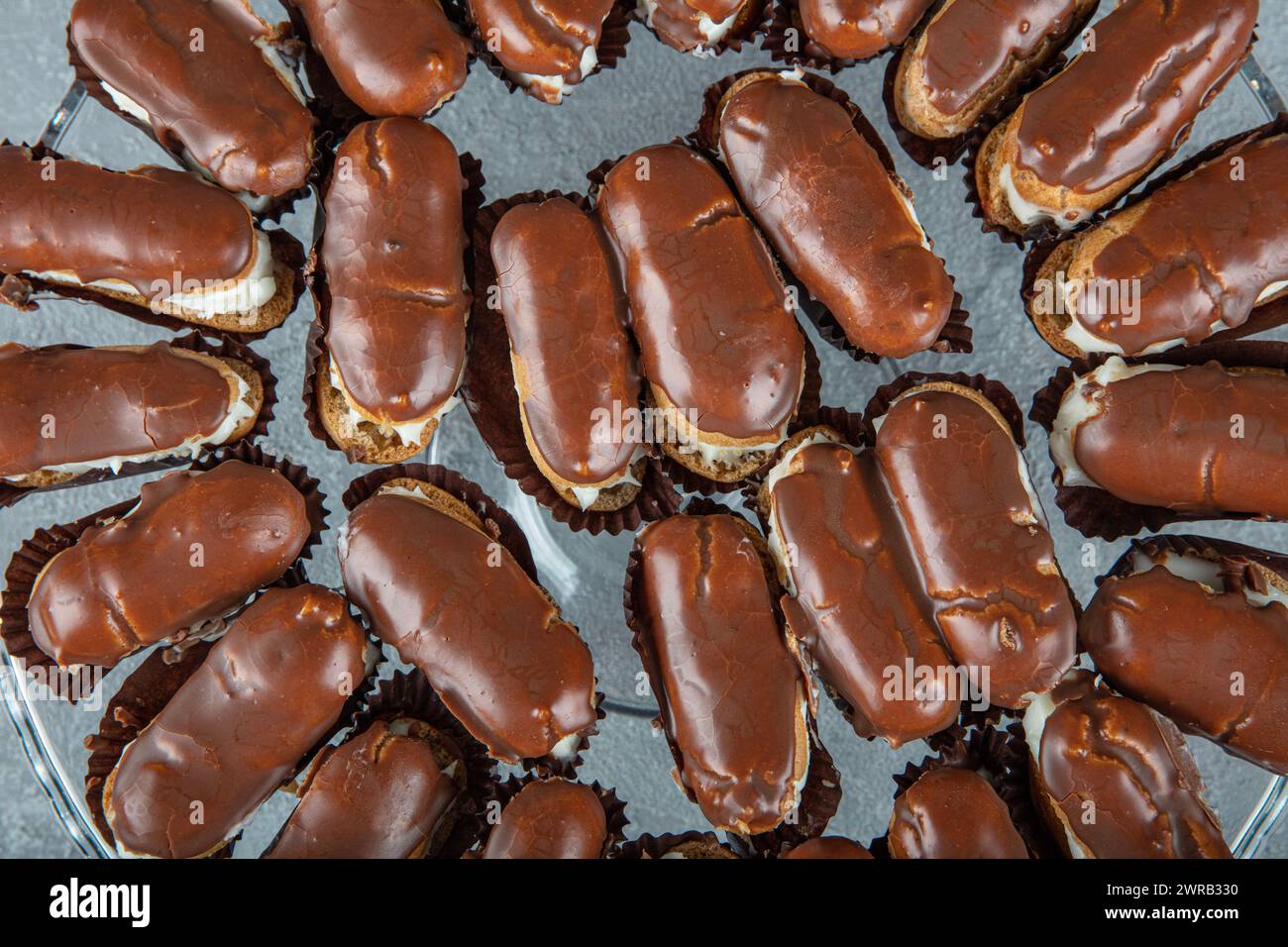Eclairs with chocolate topping on serving plate. Traditional french ...