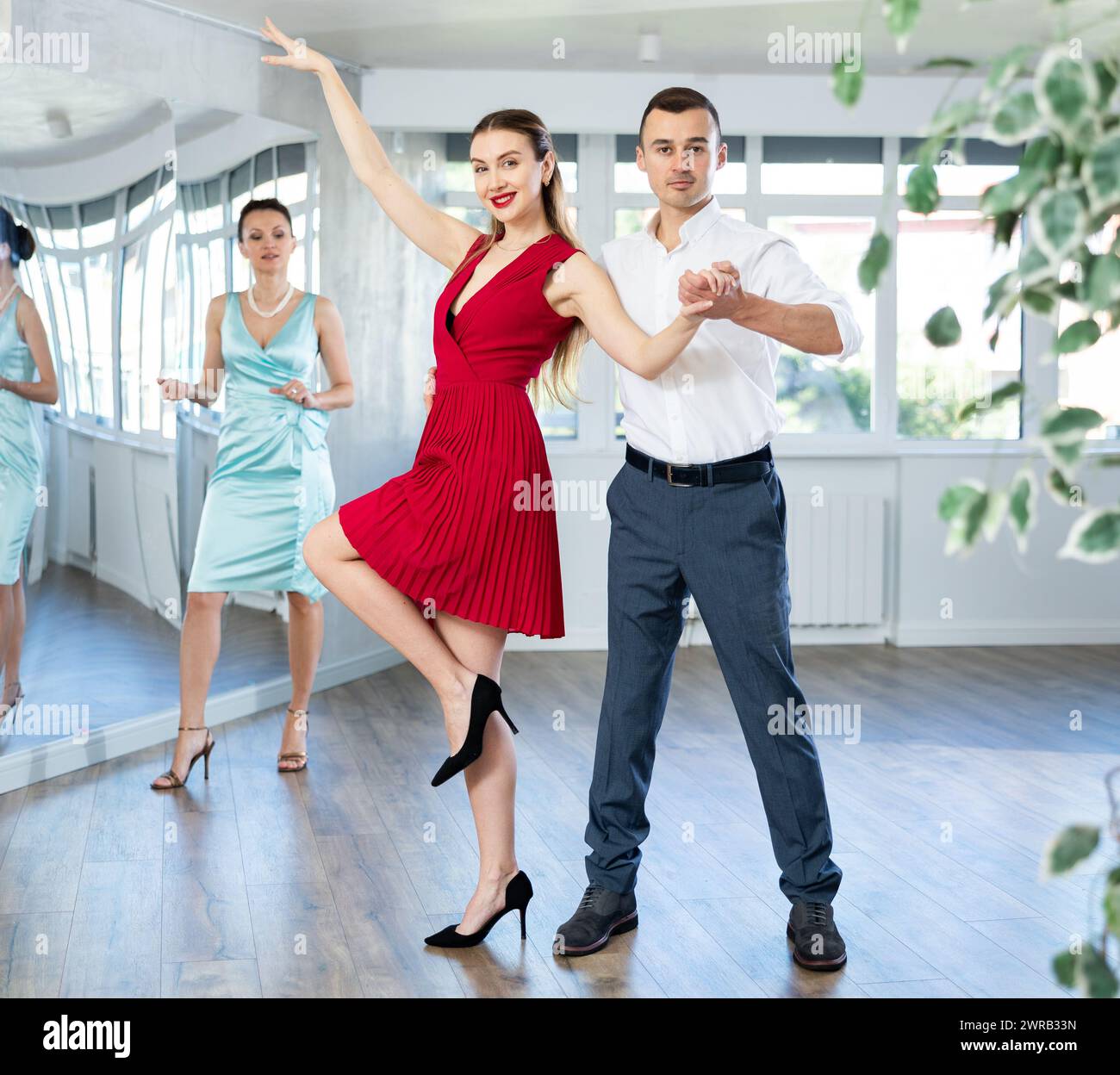 Couple in stage costumes learns tango dancing during individual lesson ...