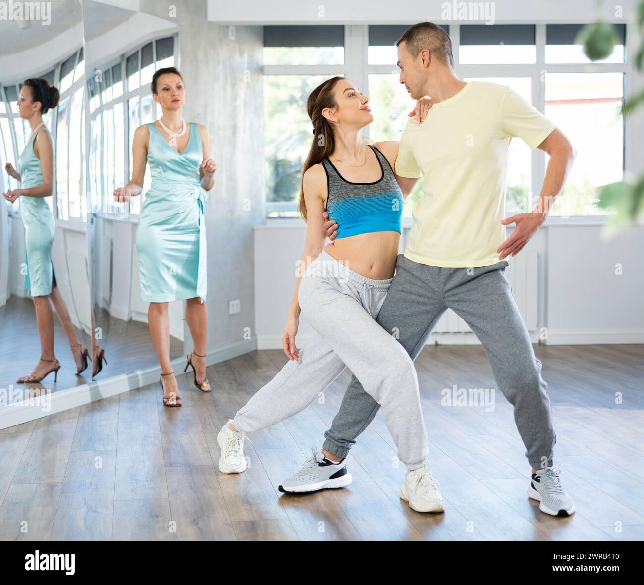 Couple practicing passionate tango guided by female dance instructor in ...