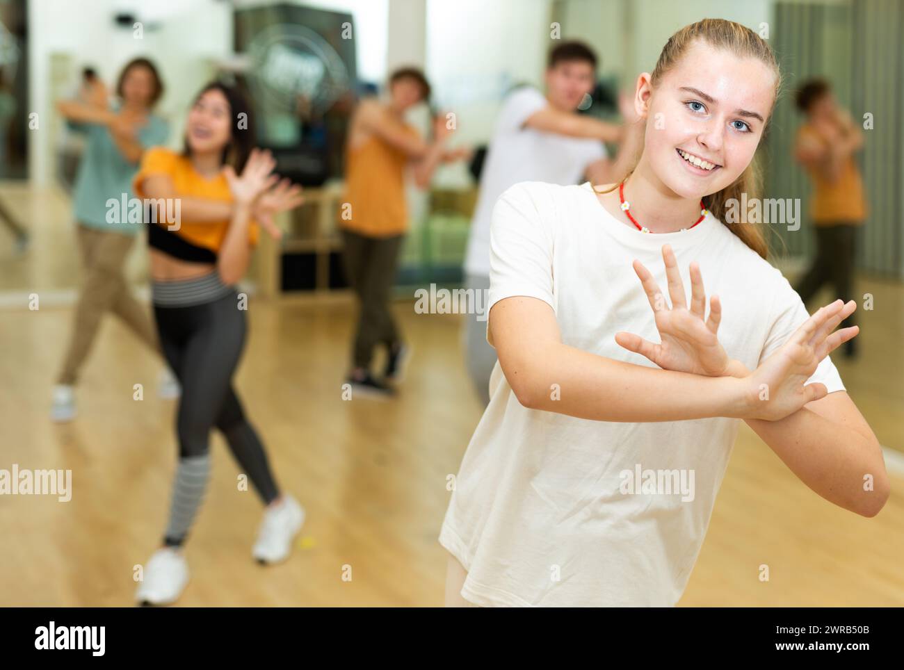 Teenage girl practicing energetic dance movements in choreography class ...