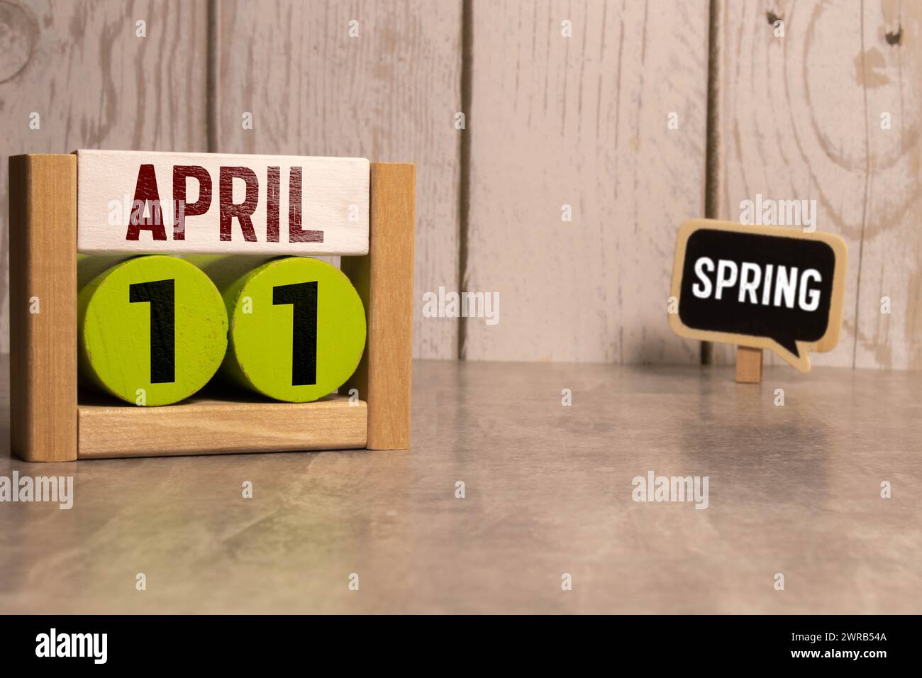 April 11 calendar date text on white wooden block with stationeries on ...