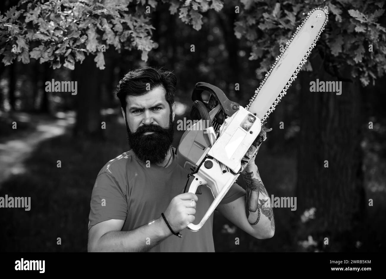 Lumberjack on serious face carries chainsaw. Deforestation is a major ...