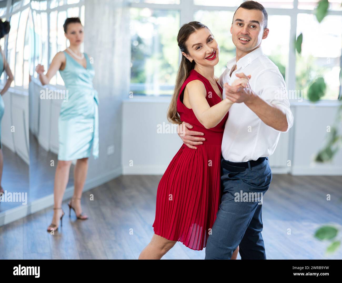 Couple in stage costumes learns tango dancing during individual lesson ...