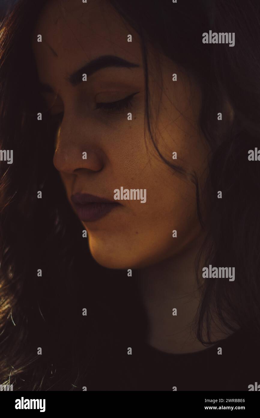 Close-up of a woman's face in a moody, introspective ambiance, a ...