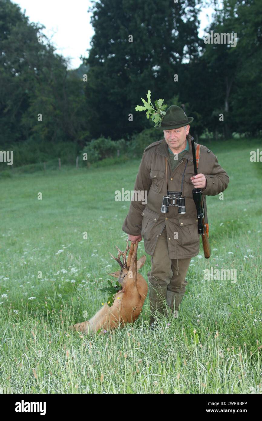 Hunter with an old european roe deer (Capreolus capreolus) and a broken ...