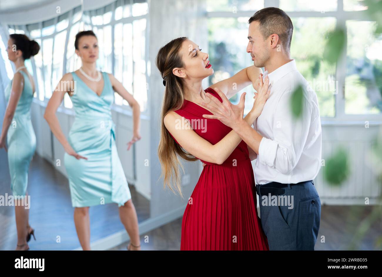Woman in red and man in formal wear rehearsing tango in pair Stock ...