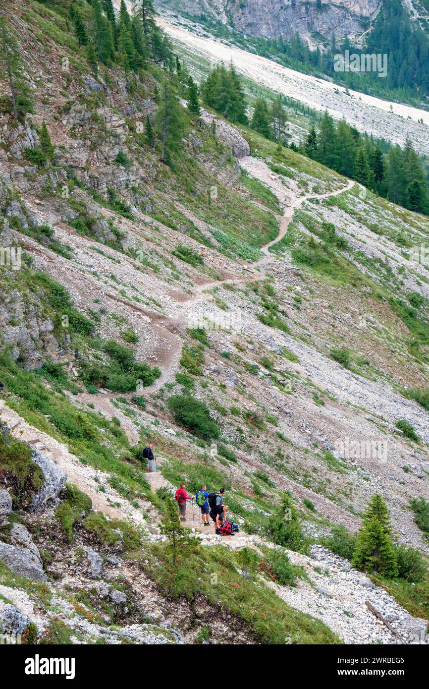 Hikers on an alpine path on the mountainside in the Dolomites mountains ...
