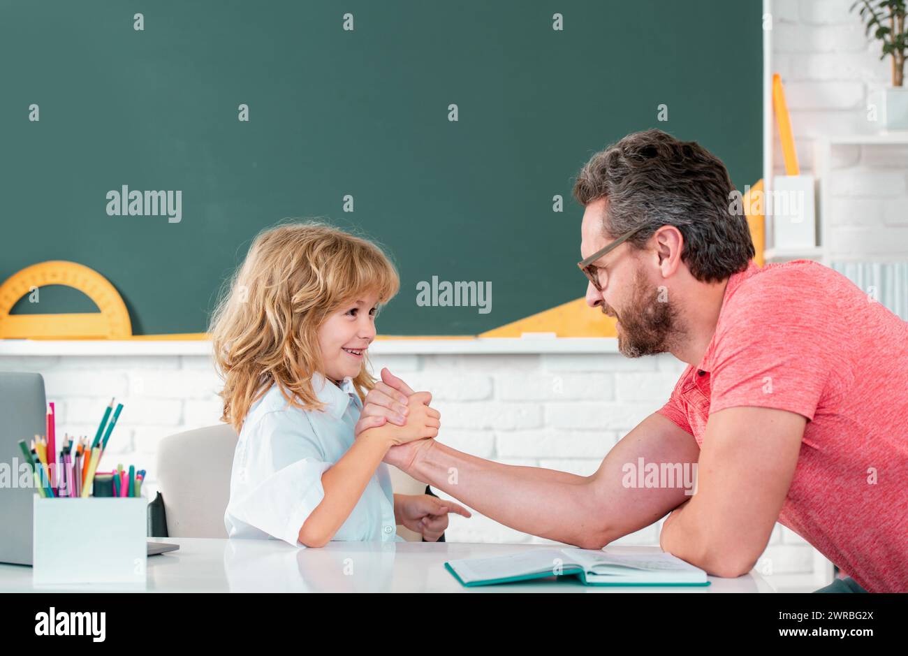 Teacher play with child student pupil from elementary school in ...