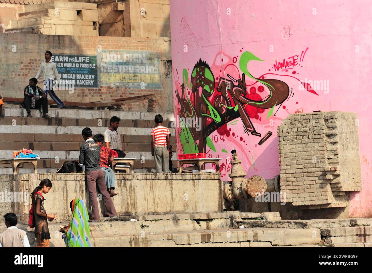Vibrant graffiti art on a wall next to people in an Indian city ...