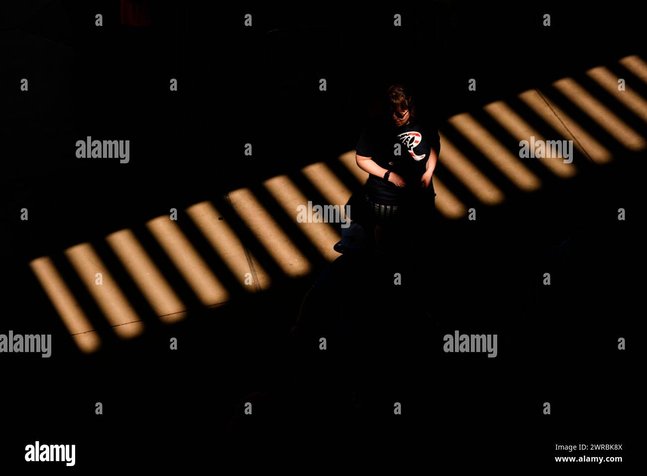 A visitor walks by a patch of light on a lower concourse before a ...