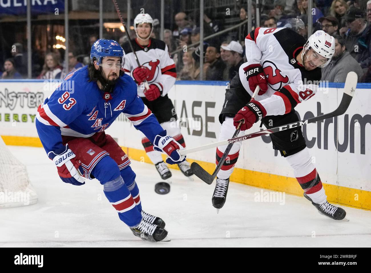 New Jersey Devils' Kevin Bahl, right, passes around New York Rangers ...