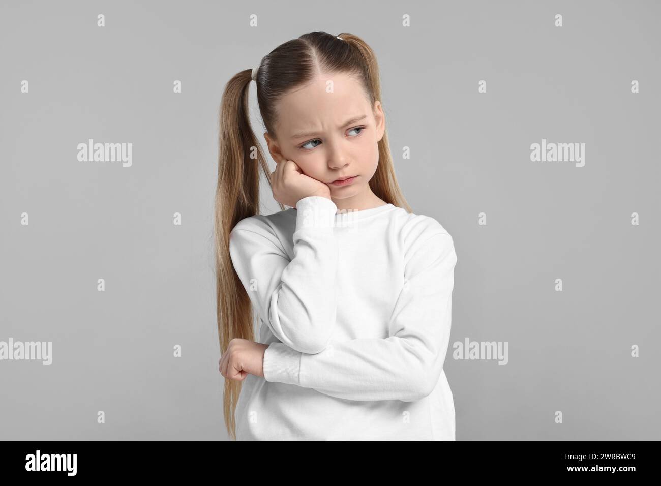 Portrait of sad girl on light grey background Stock Photo - Alamy
