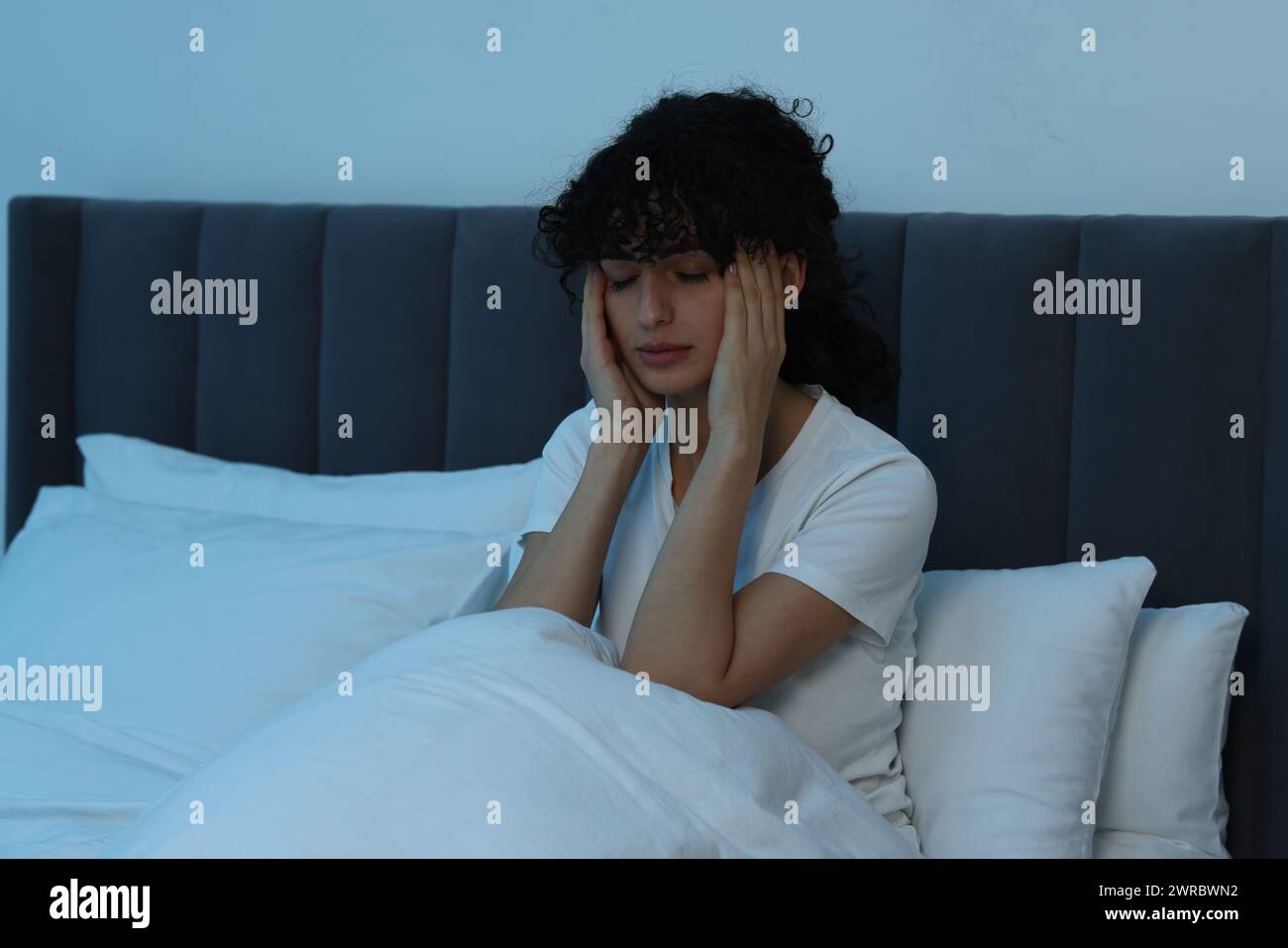 Young woman suffering from headache in bed at night Stock Photo - Alamy