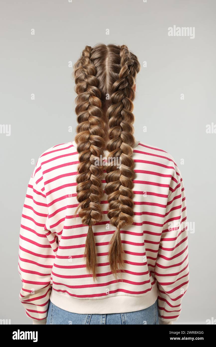 Woman with braided hair on grey background, back view Stock Photo - Alamy