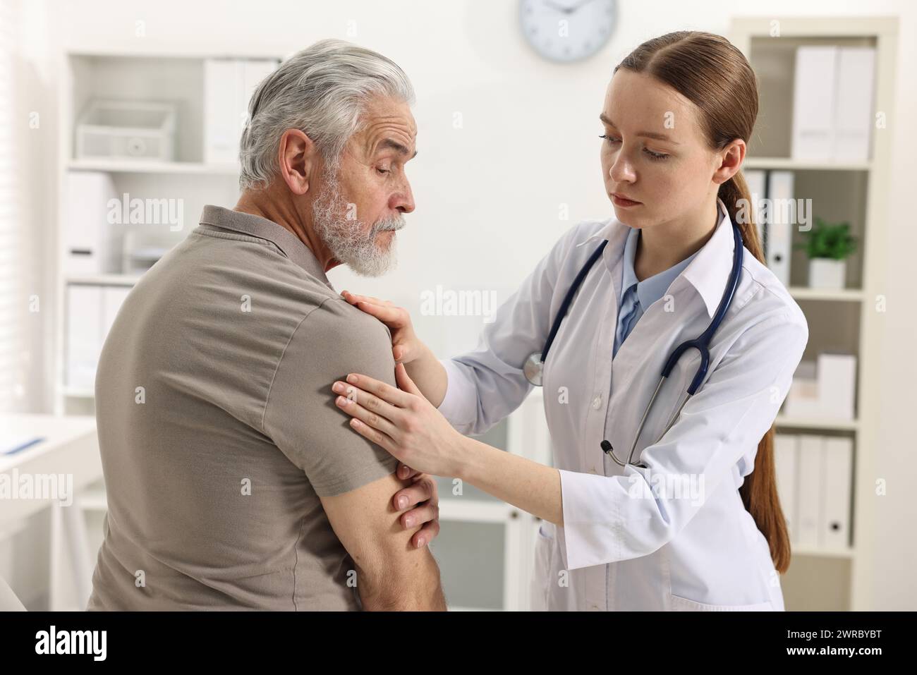 Arthritis symptoms. Doctor examining patient with shoulder pain in ...