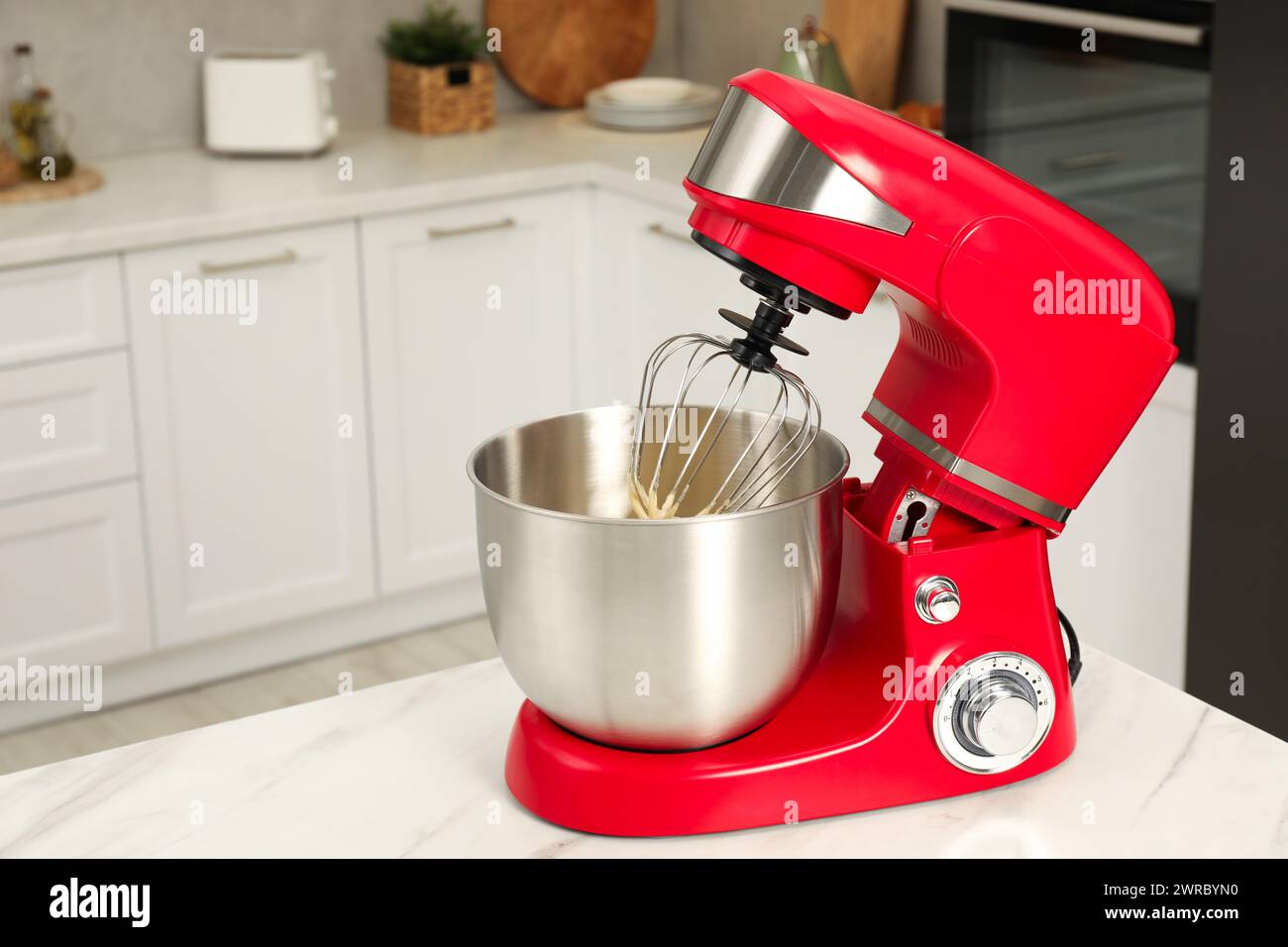 Modern red stand mixer on white marble table in kitchen, space for text ...
