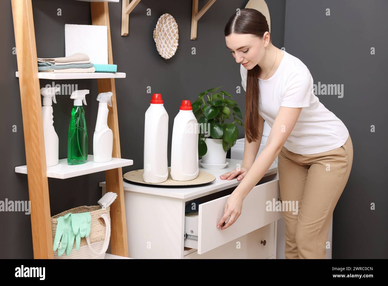 Beautiful woman opening drawer in laundry room Stock Photo - Alamy