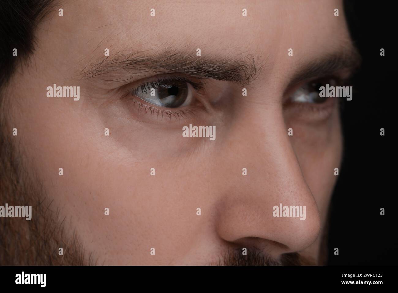 Evil eye. Man with scary eyes on black background, closeup Stock Photo ...