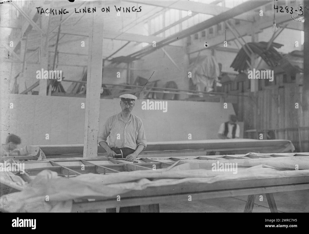 Tacking linen on wings, Photograph shows workers putting linen on the ...