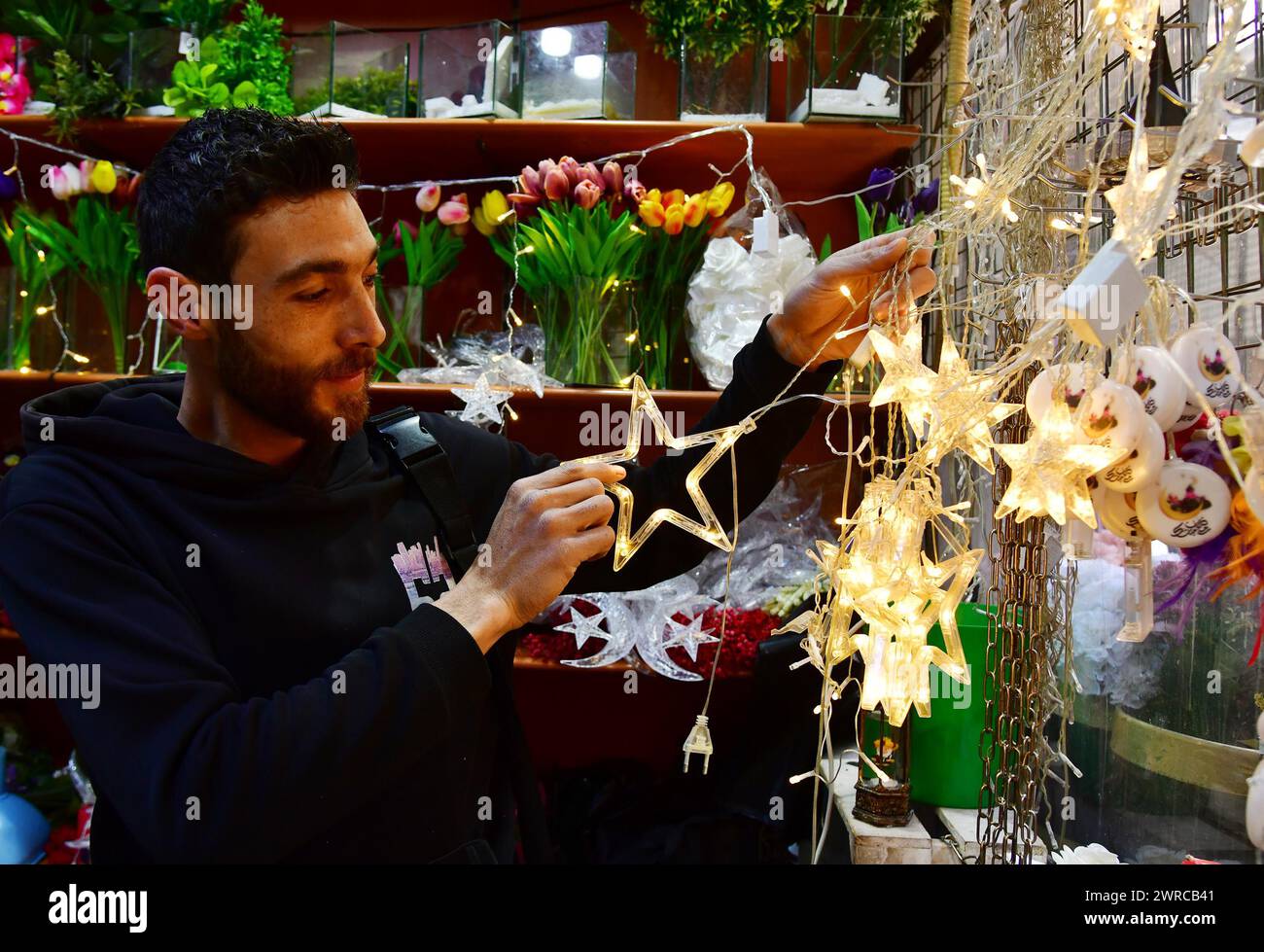 Damascus, Syria. 11th Mar, 2024. A man shows decorations for the holy ...