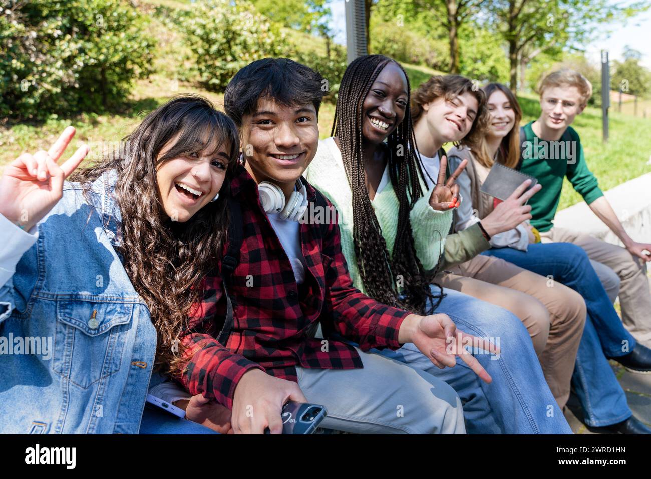 Multiracial students making peace sign and taking memories at ...