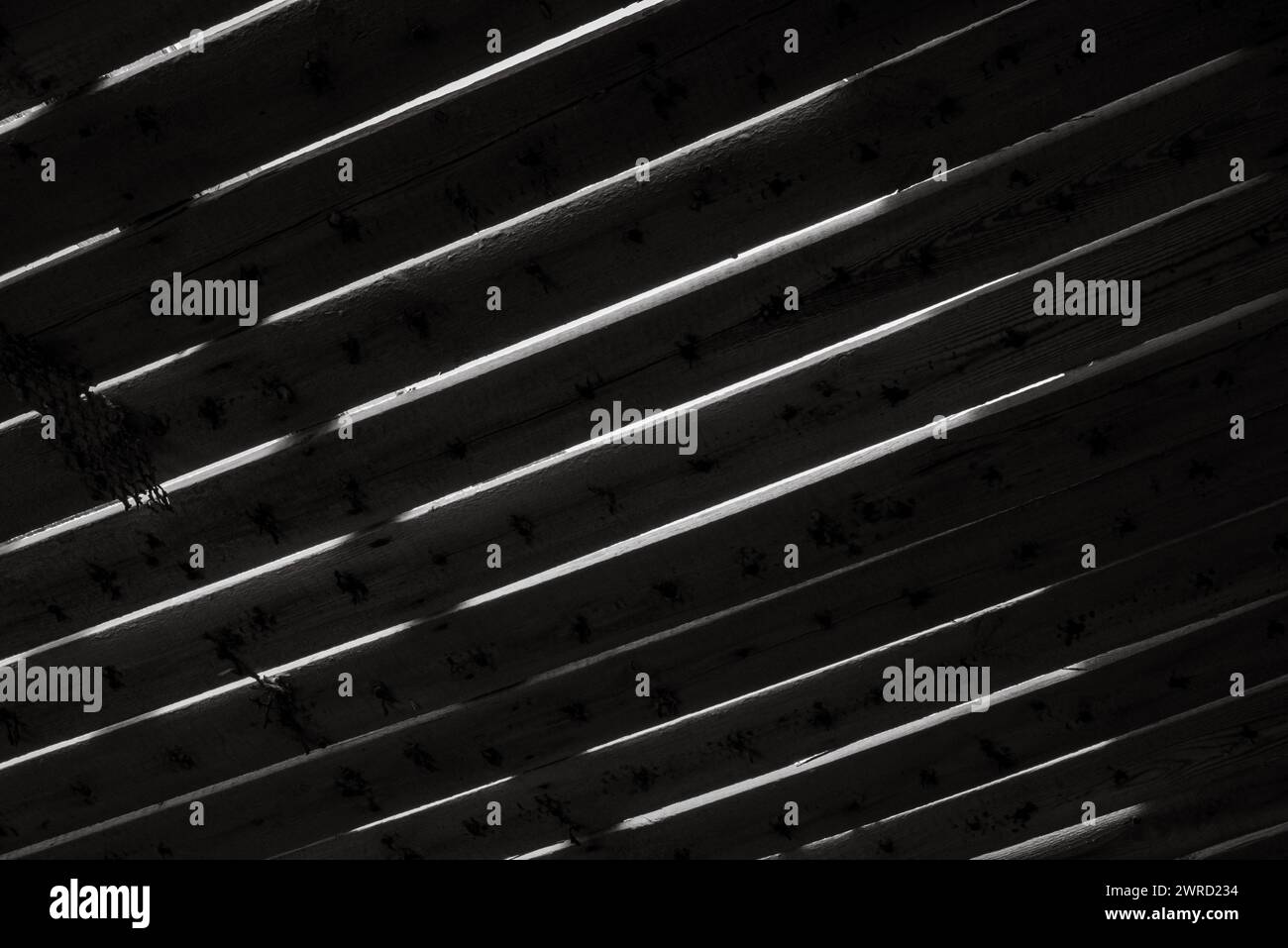 A grayscale of wooden slats with light shining through from above Stock ...