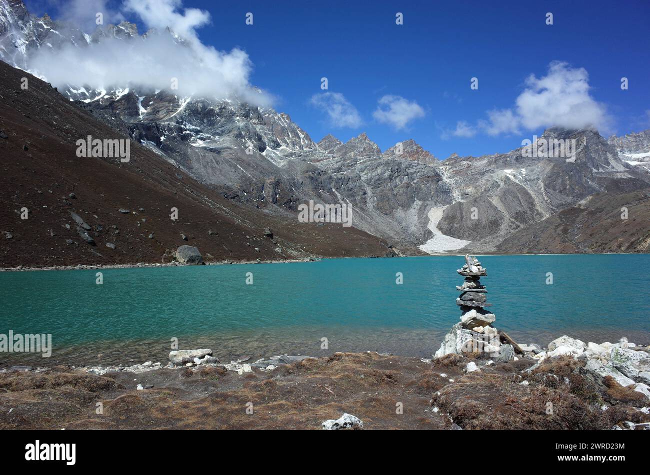 Stone pyramid next to sacred Gokyo lake with view of Renjo La pass ...
