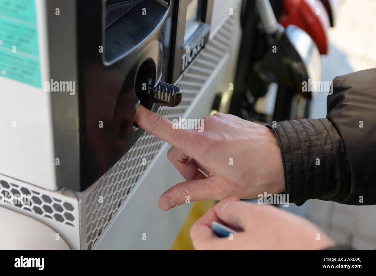 A woman's hand pushes a bank card into an ATM at a gas station Stock ...