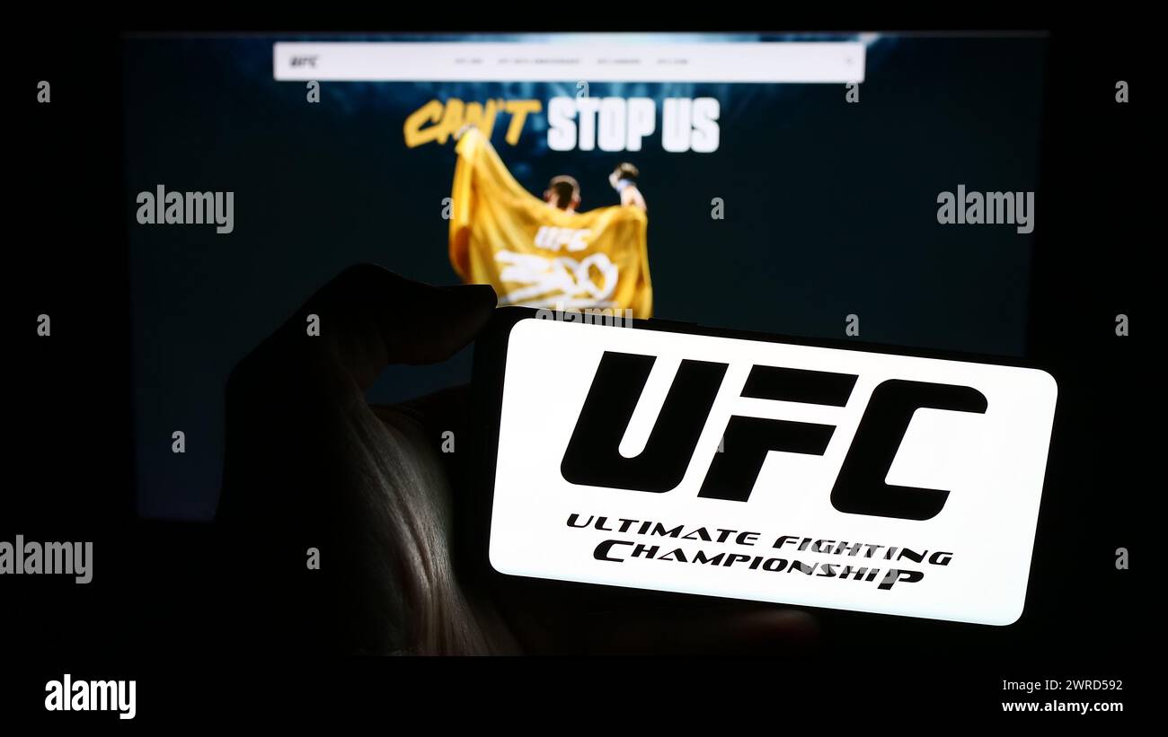 Person holding mobile phone with logo of martial arts company Ultimate ...