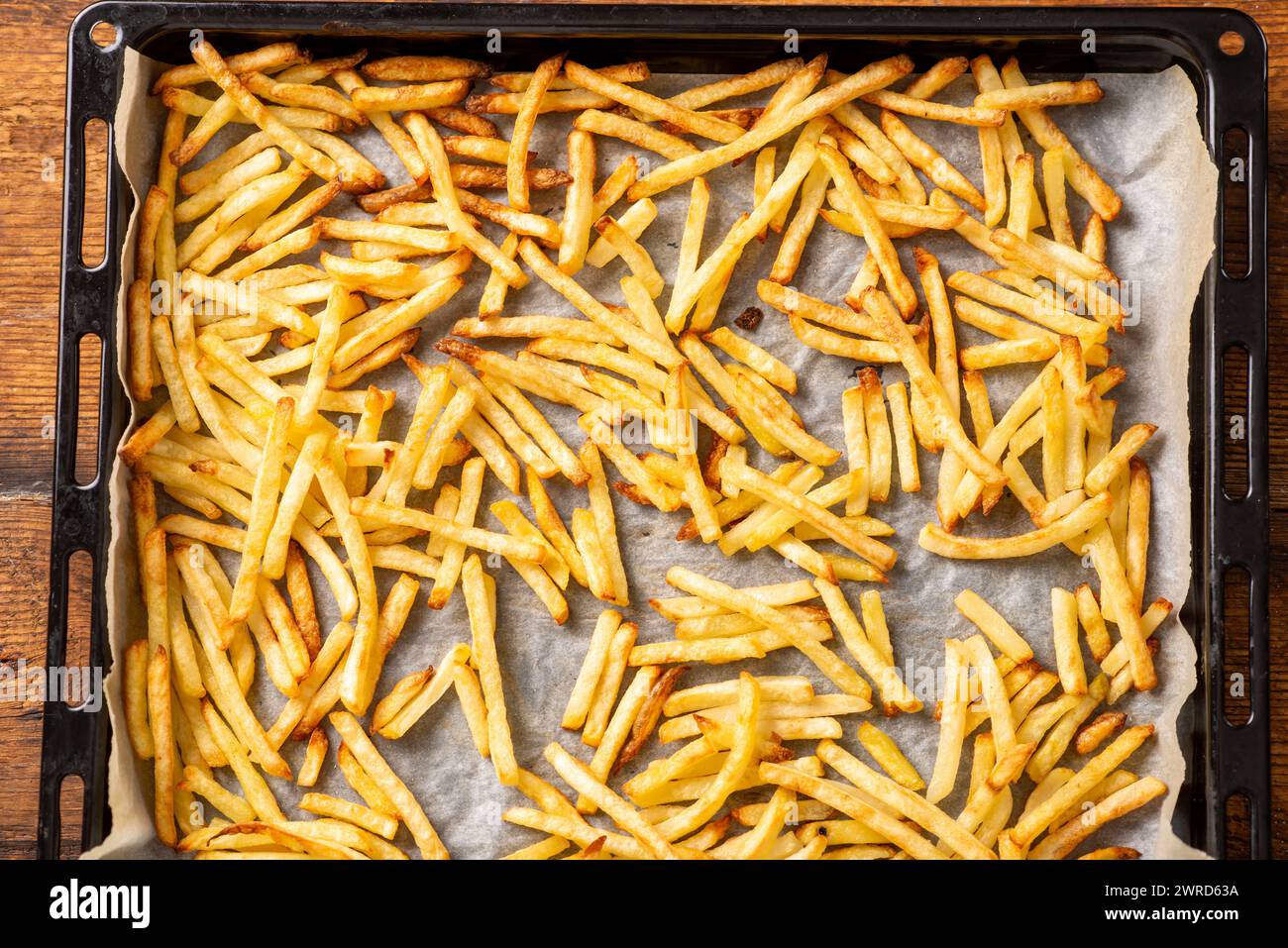 fried french fries lying on baking paper. Cooking frozen French fries ...