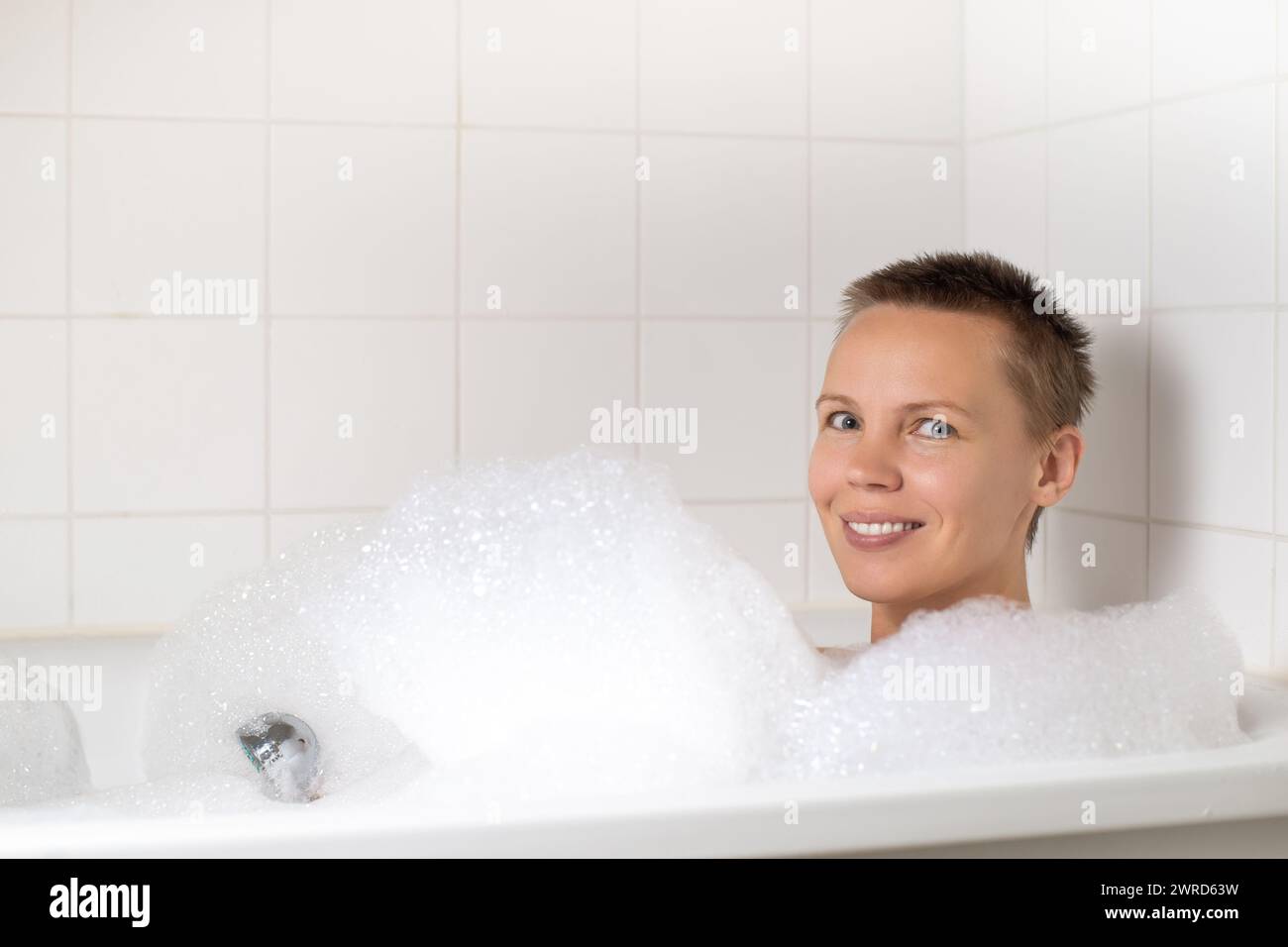 Middle-aged lady indulging in a luxurious bubble bath Stock Photo - Alamy