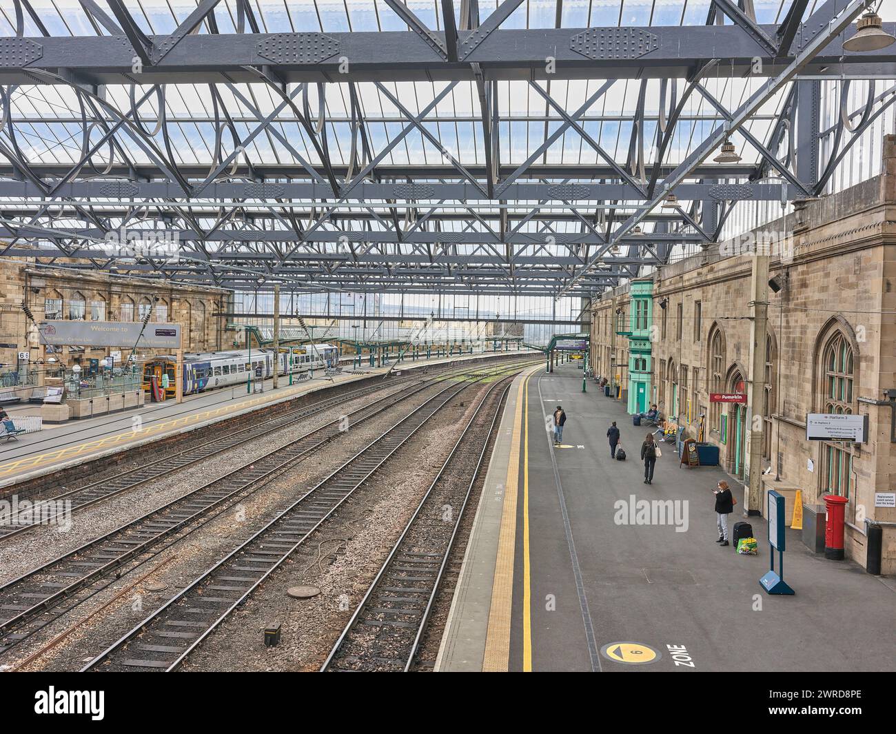 Passengers wait for a train on a platform at the railway station in Carlisle, England Stock ...