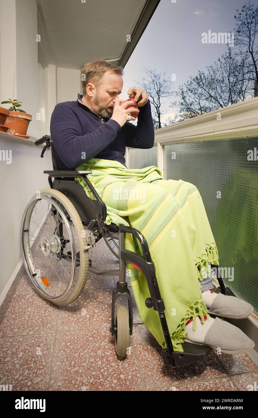 Disabled man on wheel chair enjoying nice day on balcony Stock Photo ...