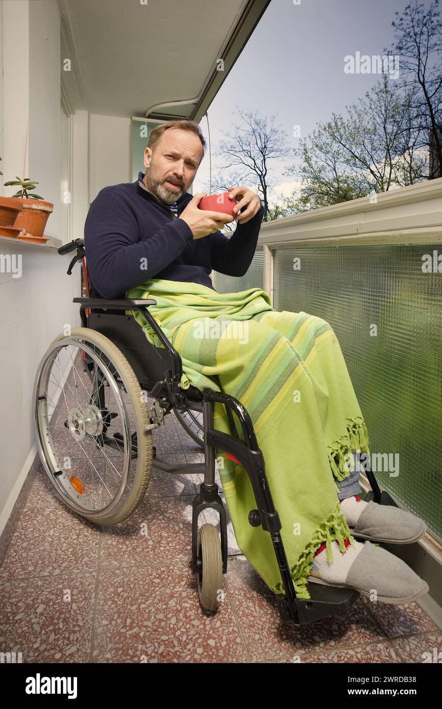 Disabled man on wheel chair enjoying nice day on balcony Stock Photo ...