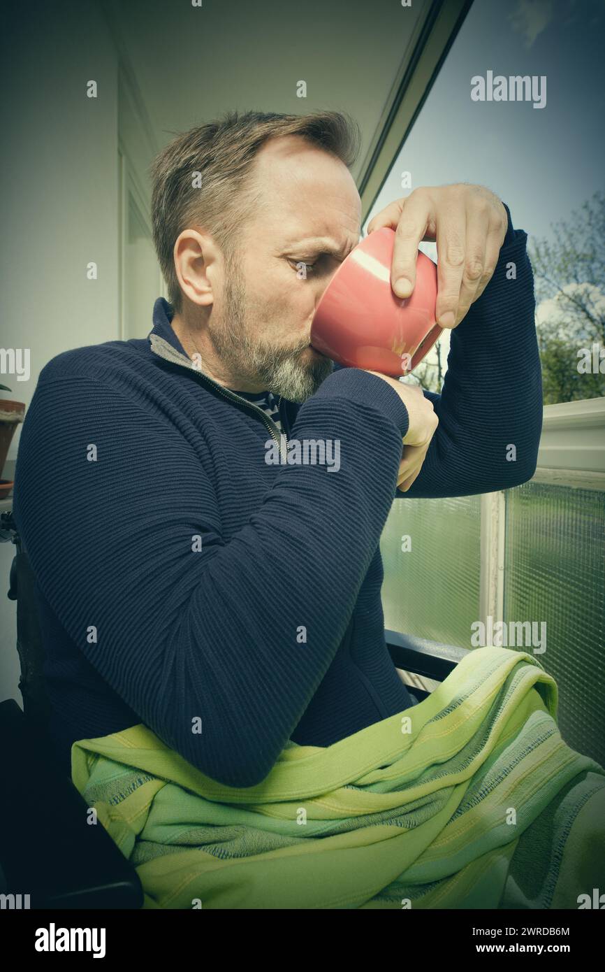 Disabled man on wheel chair enjoying nice day on balcony Stock Photo ...